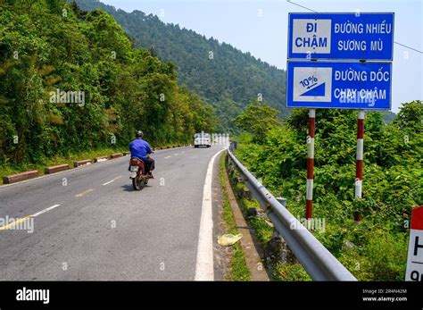 A Car And Moped Drive Down National Route 1 Road At Hai Van Pass