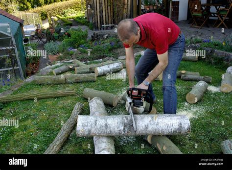 Man Cutting Tree Trunk Stock Photo Alamy