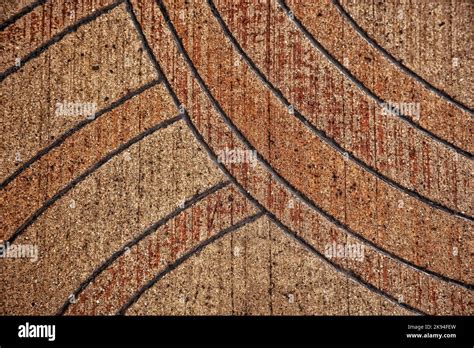 generic design detail of curved lines on an old pavement in orange and