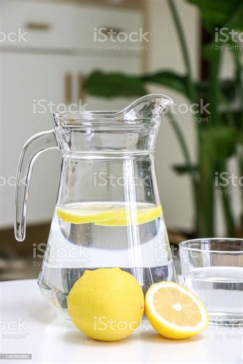 유리 주전자와 건강하고 상쾌한 천연 레몬 물 레모네이드 가득 찬 레몬과 얇게 썬 레몬의 밝은 이미지가 흰색 테이블에 표시됩니다 물에 대한 스톡 사진 및 기타 이미지 Istock