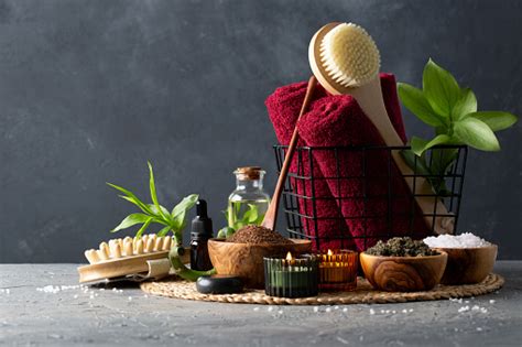 스파와 목욕 컨셉 지상 커피 스크럽 녹차 스크럽 바다 소금 바디 마사지용 오일 바다 돌 수건 및 바디 브러시가 어두운 배경에 있습니다 공간을 복사합니다 수건에 대한 스톡