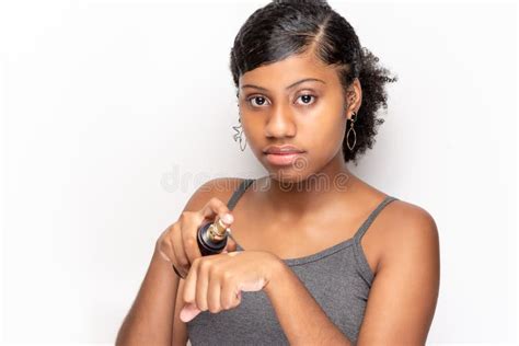 Portrait Of Beautiful Dark Skinned Girl Looks Into Camera While Tasting