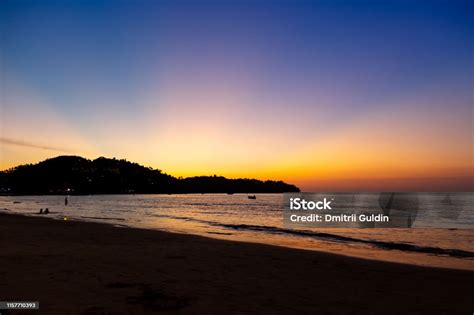 사람들은 모래 해변에서 일몰을 즐길 수 있습니다 산의 배경에 대한 파란색 오렌지 색조의 아름다운 석양을 설정합니다 계절에 대한 스톡 사진 및 기타 이미지 Istock