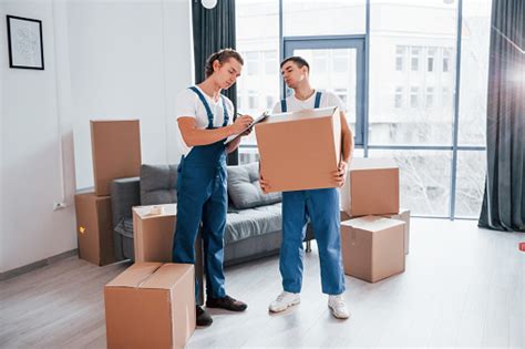 메모장을 문서와 함께 보관합니다 방에서 실내에서 일하는 파란색 유니폼을 입은 두 명의 젊은 이주 청년 남자에 대한 스톡 사진 및 기타 이미지 Istock