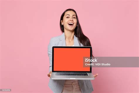 분홍색 파스텔 배경에 고립 된 빈 빈 화면으로 노트북 Pc 컴퓨터를 들고 줄무늬 재킷에 젊은 여자를 웃 고의 초상화 사람들은