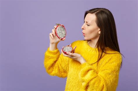 모피 스웨터 지주에 젊은 여자를 의아해 신선한 피타 하 야의 Halfs를 찾고 보라색 파스텔 배경에 고립 된 드래곤 과일 사람들은 생생한 라이프 스타일 휴식 휴가 개념입니다