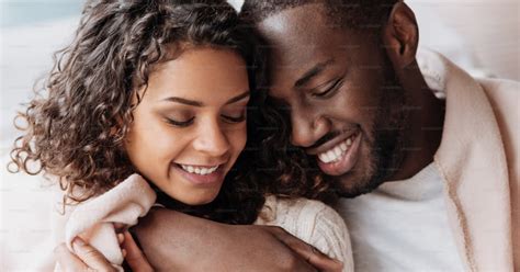 사랑에 빠져서 행복합니다 긍정적인 젊은 기뻐하는 아프리카계 미국인 부부는 카페에 앉아 담요로 덮여 사랑을 표현하고 포옹합니다 사진 Unsplash의 여성 이미지