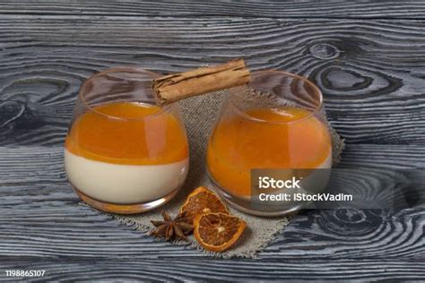 유리 잔에 젤리의 두 층 크림과 귤 젤리 계피는 젤리 잔에 붙어 있습니다 장식 향신료 근처 검은 색과 녹색 페인트 기모 보드의 표면에 0명에 대한 스톡 사진 및 기타 이미지