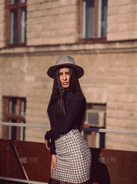 戴着长头发帽子的时髦女孩在大楼的背景下摆姿势素材 花瓣网