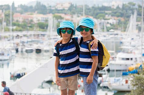 可爱的小男孩，学龄前儿童，戴着太阳镜在港口的街道上摆姿势