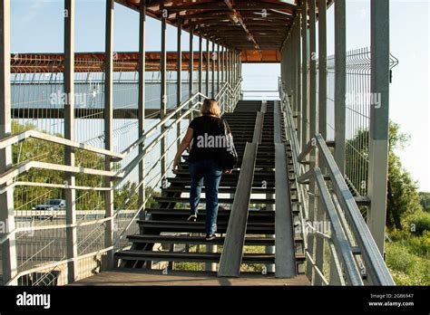 A Woman Climbs The Steps Of An Overhead Pedestrian Crossing The Photo
