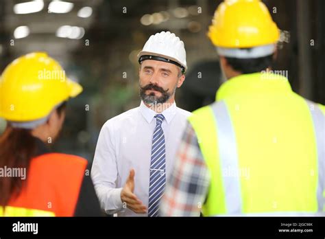 Architect Civil Engineer And Worker Looking At Plans And Blueprints