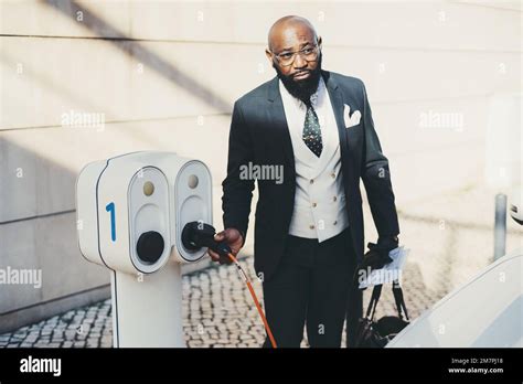 An Elegant And Classy Black Man Rocking An Unshaved Black Beard Glasses And A Tailored Suit