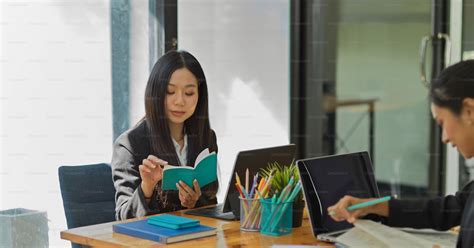 두 명의 여성 직장인이 사무실에서 서로 마주 앉아 함께 일하는 크롭 샷 사진 Unsplash의 기술 이미지