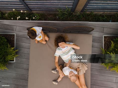 공중 무인 항공기 젊은 어머니가 자동차와 녹색 정원에서 그녀의 아기 소년 아들 형제와 함께 놀고 재미를 가족 값 따뜻한 색상 여름 장면 동유럽 라트비아 리가 가족에 대한