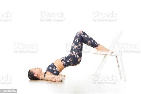 밝은 흰색 요가 스튜디오에서 젊은 스포티 한 매력적인 여성 스트레칭과 가젯으로 흰색 의자를 사용하여 회복 요가 동안 휴식 건강한 활동적인 라이프스타일 건강한 생활방식에 대한