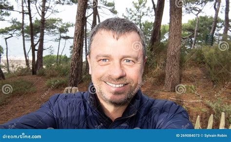 Селфи средних лет красивый мужчина 50 лет делает селфи фото с телефоном в парке морской сосны