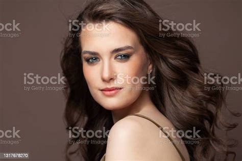 갈색 배경에 맑은 피부와 건강한 물결 모양의 머리와 예쁜 미소 여자 갈색 머리의 초상화 자연 메이크업을 가진 아름다운 여자 18 19세에 대한 스톡 사진 및 기타 이미지