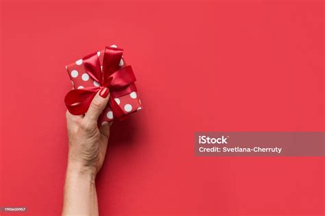 회색 배경에 빨간 활과 빨간 선물 상자를 들고 여자 손 인사말 Xmas 카드입니다 권투 의 날 위에서 볼 수 있습니다 빨간색 배경에 대한 스톡 사진 및 기타 이미지 Istock