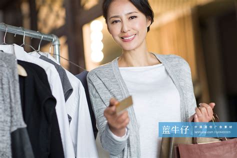 中年女子拿着信用卡在服装店买衣服 蓝牛仔影像 中国原创广告影像素材