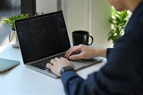 A Closeup Photograph Of A Software Developer Typing On A Laptop While
