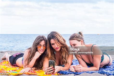 우정 숙박에서 3 명의 아름 다운 여자의 그룹 누워 편안 하 게 말하기와 집에서 친구와 함께 그녀의 여름 라이프 스타일을 공유 하는 스마트폰을 사용 하 여 해변에서 웃음과