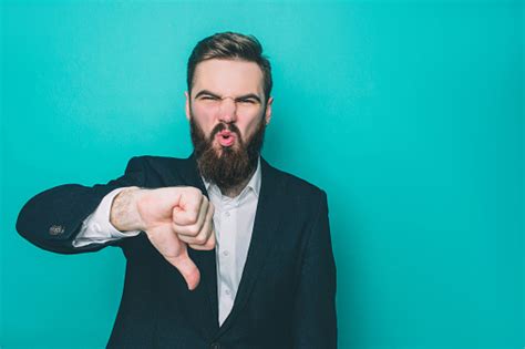 남자는 서 서 그의 큰 엄지 손가락을 보여줍니다 그는 행복 하 고 만족 하지 않습니다 이 사람은 화가 난다 파란색 배경에 고립입니다 감독에 대한 스톡 사진 및 기타 이미지