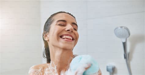 집에서 샤워를 하는 동안 각질 제거 목욕 스폰지를 사용하여 피부에 거품이 있는 쾌활한 아가씨 사진 Unsplash의 사람 이미지