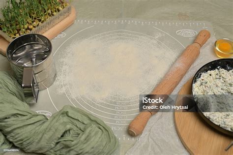 조리대에 밀가루를 뿌린 실리콘 깔개 밀대 체 달걀 녹색 수건 마이크로 그린 콩나물 파슬리와 딜 그린을 곁들인 코티지 치즈를 식탁에 올려 놓습니다 가정 요리 베이킹 가정