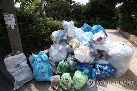 놀이터 앞에 가득 쌓여있는 쓰레기 더미 연합뉴스