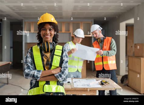 Portrait Female Engineer Project Manager With Construction Gear And Project Blueprint