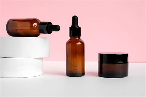 호박색 유리 점적기 화장품 병 흰색 연단 자연 스킨 케어 Spa 뷰티 제품 디자인 분홍색 배경에 미네랄 유기농 오일 모형 기름진 피펫 얼굴과 몸 치료 정면보기 0명에 대한