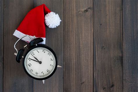 텍스트 복사 공간와 어두운 소박한 나무 배경에 블랙 빈티지 알람 시계와 빨간 산타 클로스 모자 0명에 대한 스톡 사진 및 기타