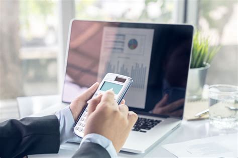 회의 회의 하는 동안 비즈니스 팀의 상위 뷰 손에 마케팅 계획과 판매 보고서 이익 금융 작업 테이블에 노트북 컴퓨터와 스마트폰 태블릿 회사의에 대 한 작업 문서