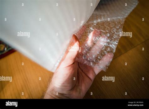 A Man Is Carefully Testing A Giant Roll Of Air Bubble Packaging Film
