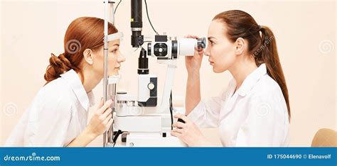 Доктор офтальмолога в лаборатории Optician экзамена с женским пациентом ...
