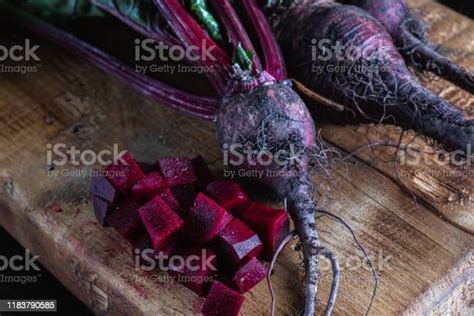 잎이 있는 수분이 많은 비트 세 개 그 중 하나는 나무 판에 다진 사탕무 옆에 놓여 있습니다 0명에 대한 스톡 사진 및 기타 이미지 Istock