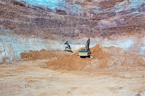 Premium Photo Open Pit Mine In Full Operation With Machinery Extracting Minerals