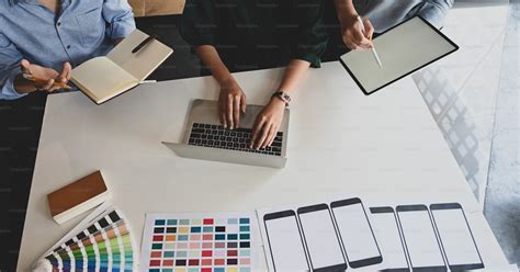 그래픽 디자인 팀이 함께 작업하고 스마트폰의 새로운 기능에 대해 브레인스토밍하는 상위 뷰 이미지입니다 협업공동 작업자회의함께 일하는 개념 사진 Unsplash의