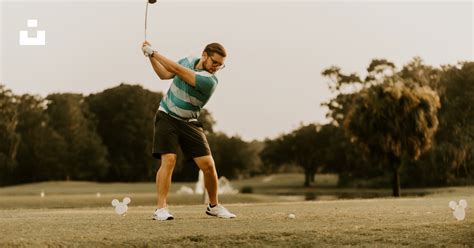 녹색과 흰색 줄무늬 탱크 탑과 검은 색 반바지를 입은 여자가 낮 동안 골프 클럽을 들고 있습니다 사진 Unsplash의 무료 골프 이미지