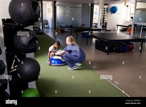 At Rehabilitation Center Caucasian Female Therapist Treats Biracial