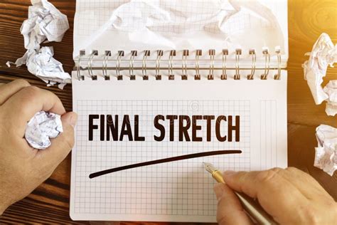 A Man Writes Text Final Stretch In A Notebook Around A Notepad And