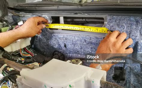 기술자는 유지 보수 및 고장 센터 콘솔 자동차를 고정하기 위해 테이프 측정 검사 콘센트 공기를 사용합니다 자동차 자동차 기술의 자동차 엔진 부품 Brand Name