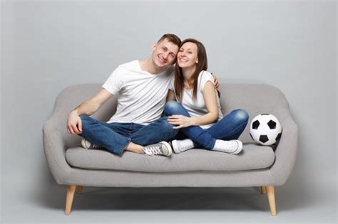 흰색 T 셔츠에 아름 다운 커플 여자 남자 축구 팬 지원 최대 응원 축구 공 포옹 회색 배경에 고립으로 좋아하는 팀 사람들의 감정 스포츠 가족 레저 라이프 스타일 개념입니다