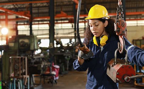 안전 안전모 서 있고 유지 보수 작업을 하거나 중공업 제조 공장에서 오버헤드 크레인 원격 제어를 확인하는 보호 유니폼을 입은 기술자 엔지니어 또는 작업자 여성 16 17