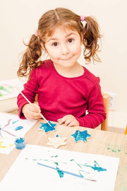 Premium Photo Portrait Of Cute Girl Smiling On Table
