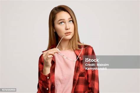스튜디오 체크 무늬 셔츠에 아름 다운 젊은 여자의 초상화 그녀는 신중은 하 고 그녀의 입술과 그녀의 유리를만 지 러시아에 대한