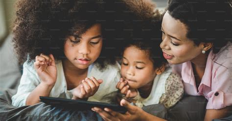 미국 아프리카 가족은 집에서 함께 시간을 보내고 있으며 어린 소년 소녀 어머니 태플릿을 사용하는 형제 웃는 아이들 소파 베드에서 노는 엄마 사진