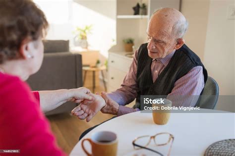 남편이 느끼고 있는 손목 통증 때문에 남편의 손을 검사하는 노인 여성 2명에 대한 스톡 사진 및 기타 이미지 2명 70 79세 가정 생활 Istock