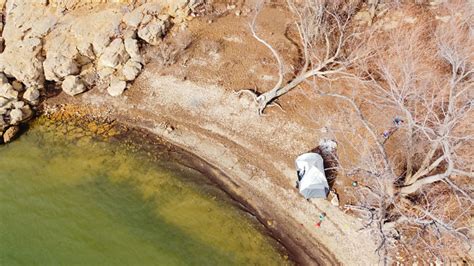 미국 텍사스 주 그레이프바인 레이크의 바위 해안선과 사암 절벽을 따라 대형 가족 텐트 근처의 낚싯대 꼭대기 보기 0명에 대한 스톡 사진 및 기타 이미지 Istock